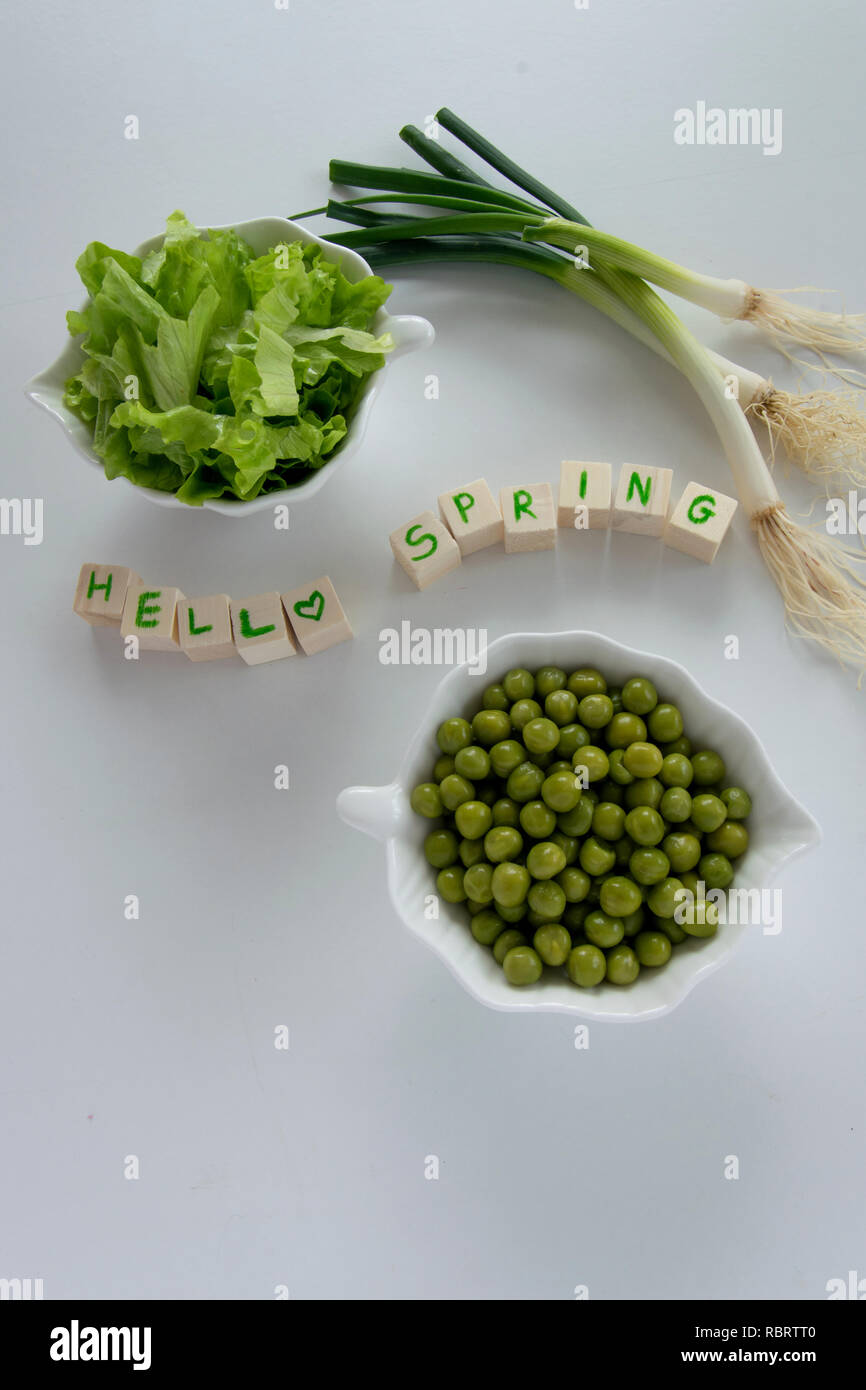 Fresh raw spring vegetables on white background, text " Hello spring ...