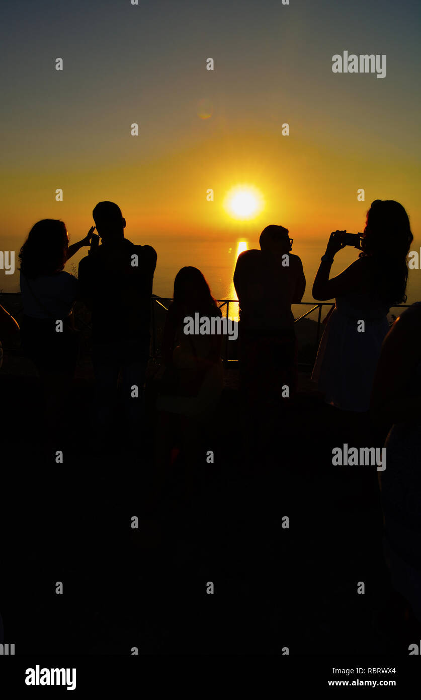 Silhouettes of people at viewpoint on the top of the hill, watching and ...