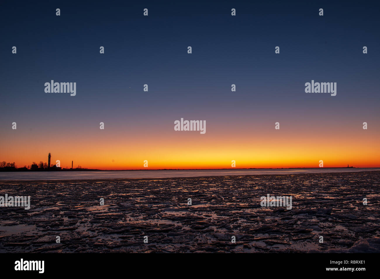 dramatic red sunset over the frozen sea on the beach with ice blocks in ...