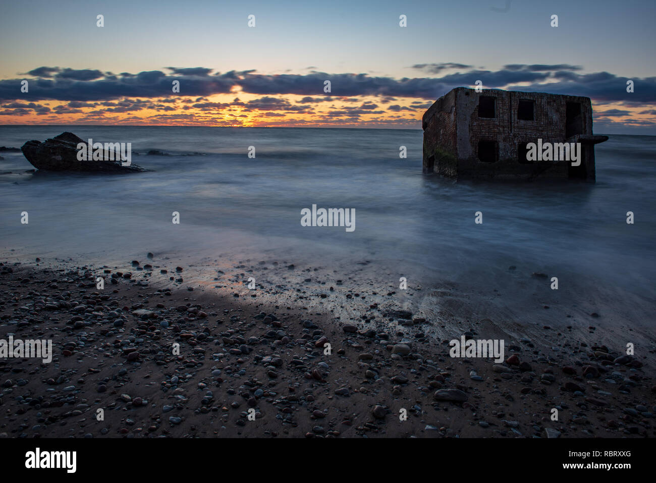 ruins of old war fort in Liepaja, Latvia at sunset time in calm sea ...