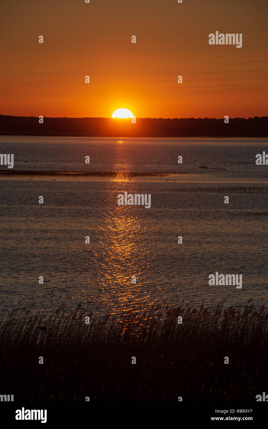 beautiful. red sunset over the sea, lake with clear sky and reflections ...