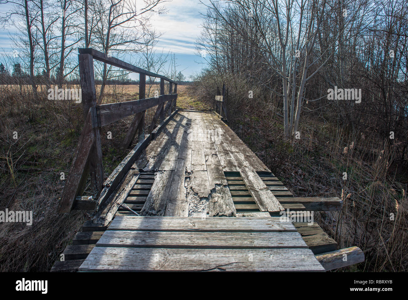 country gravel road in perspective with old and broken asphalt in ...