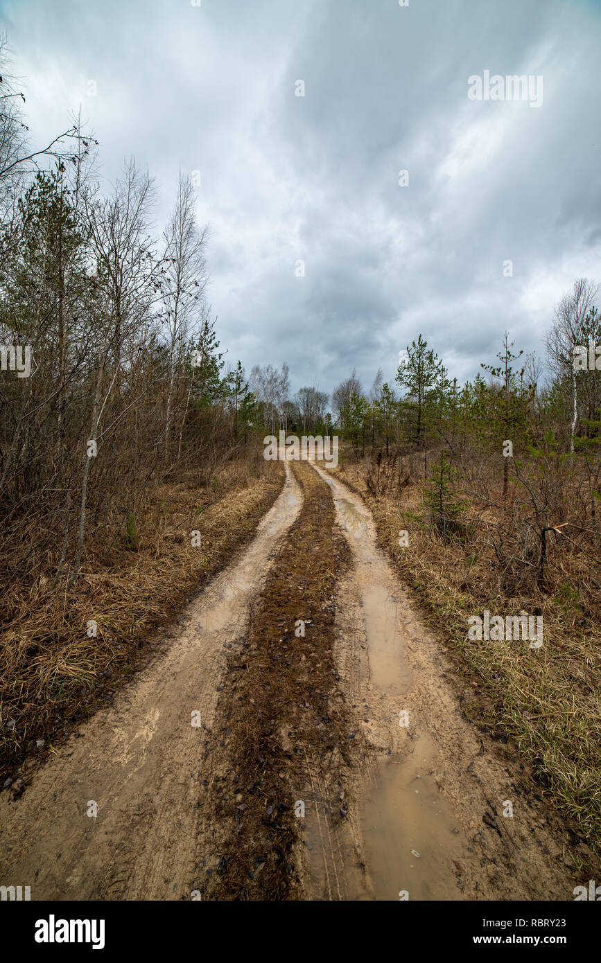 country gravel road in perspective with old and broken asphalt in ...