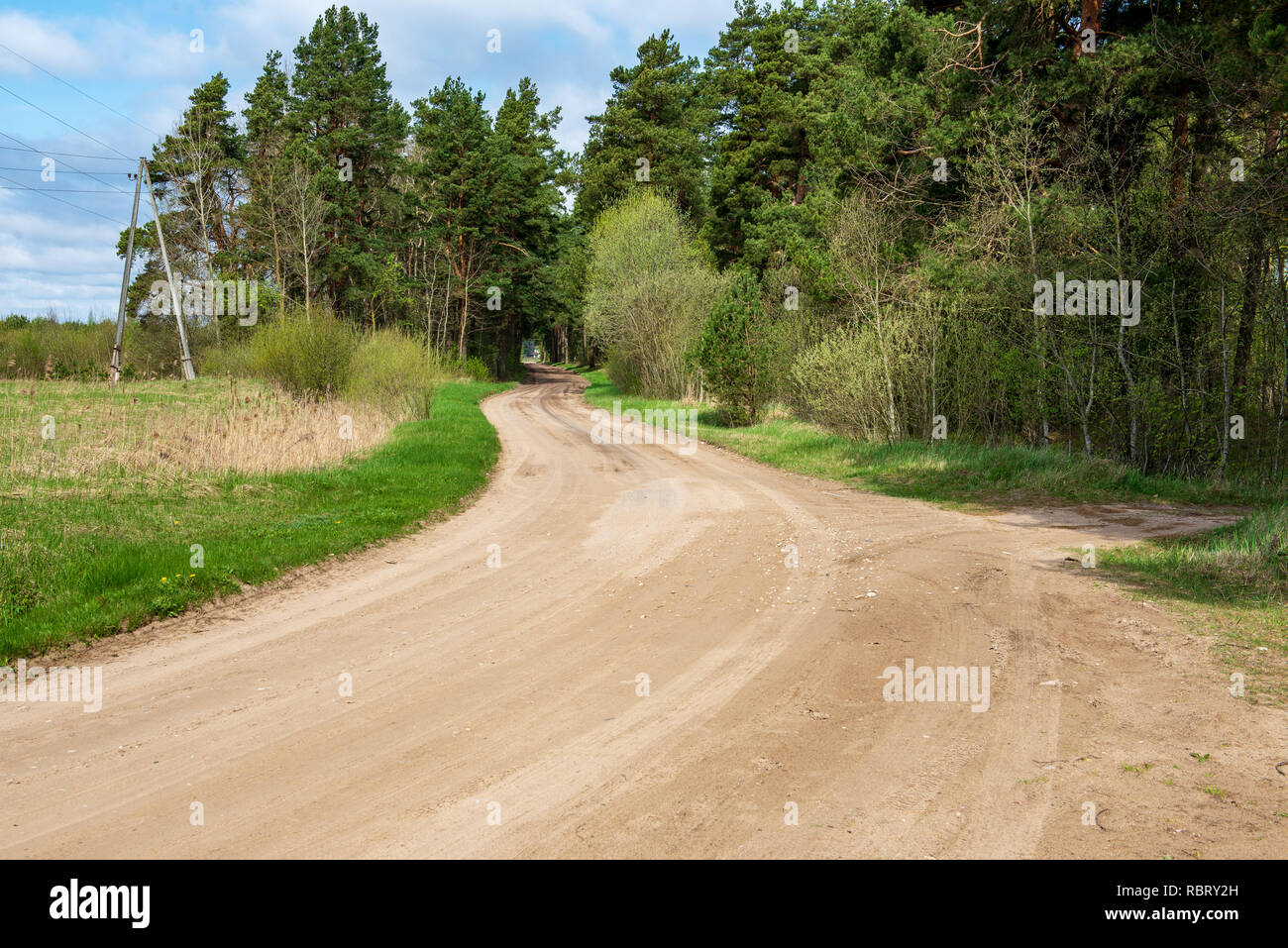 country gravel road in perspective with old and broken asphalt in ...