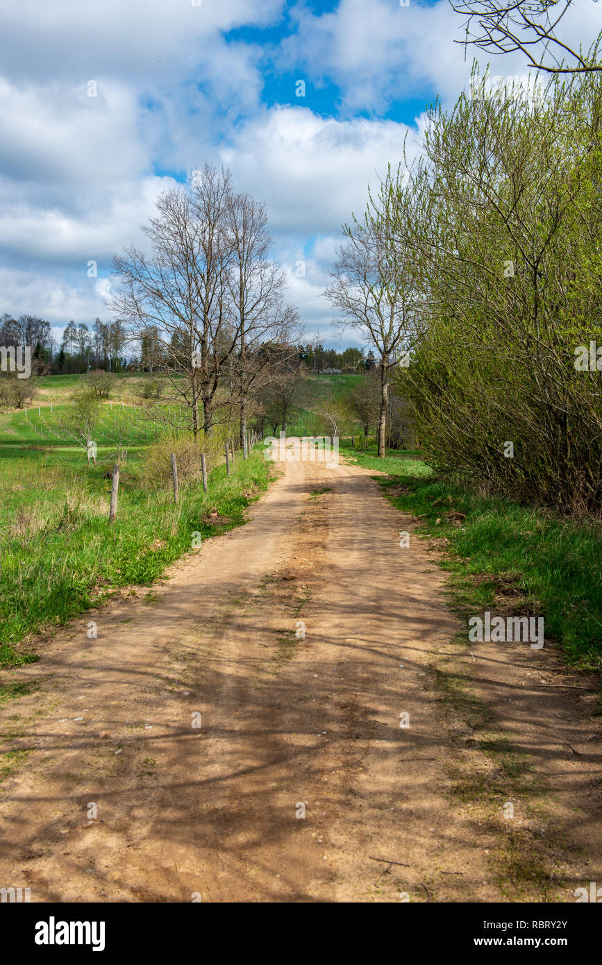 country gravel road in perspective with old and broken asphalt in ...