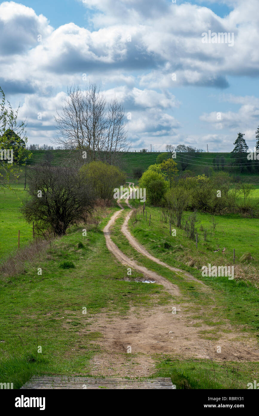 country gravel road in perspective with old and broken asphalt in ...