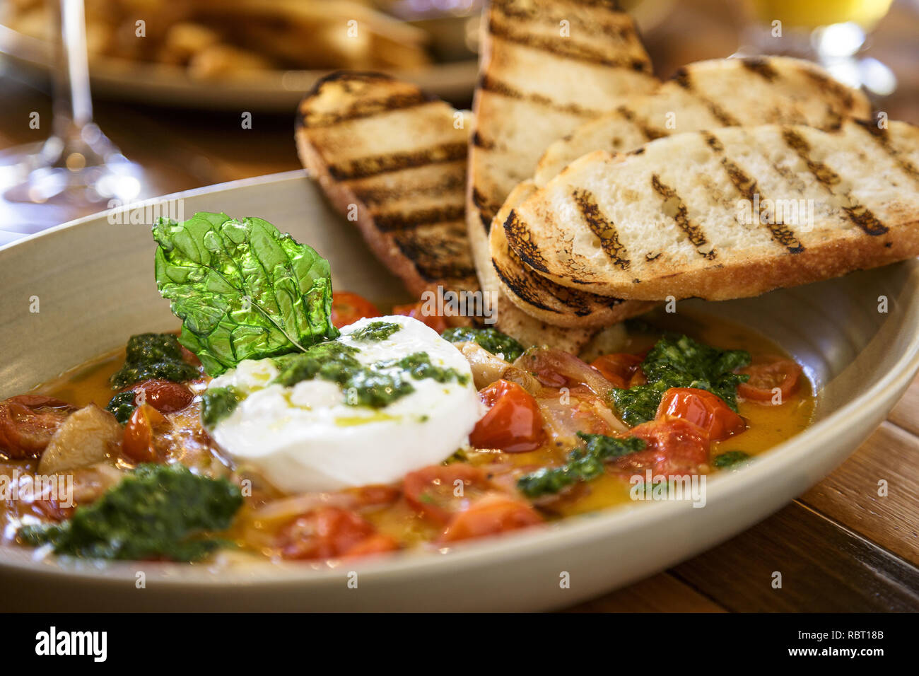 Burrata with toasted bread close up Stock Photo - Alamy