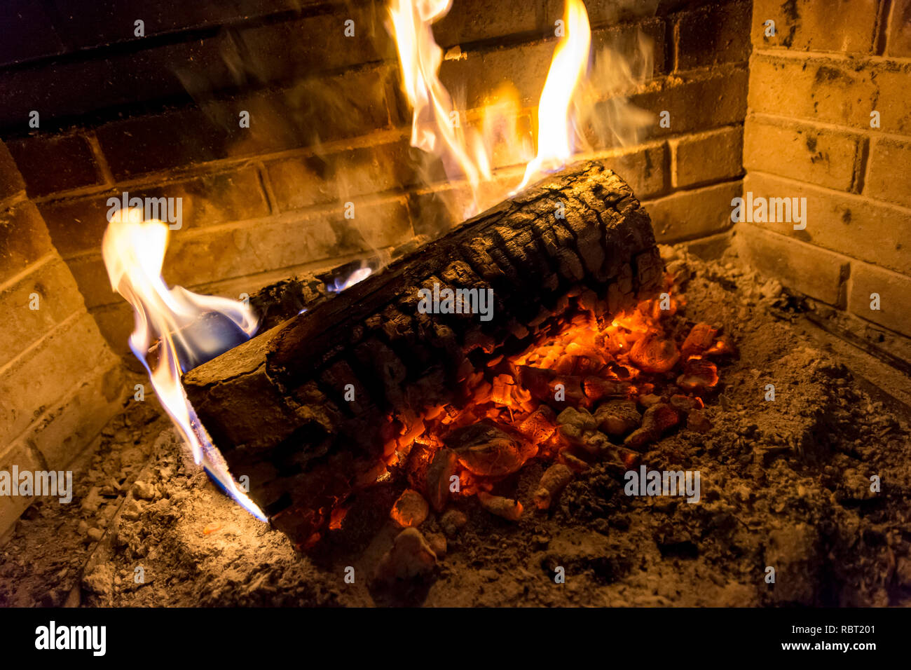 Burning logs in stone fireplace hi-res stock photography and images - Alamy