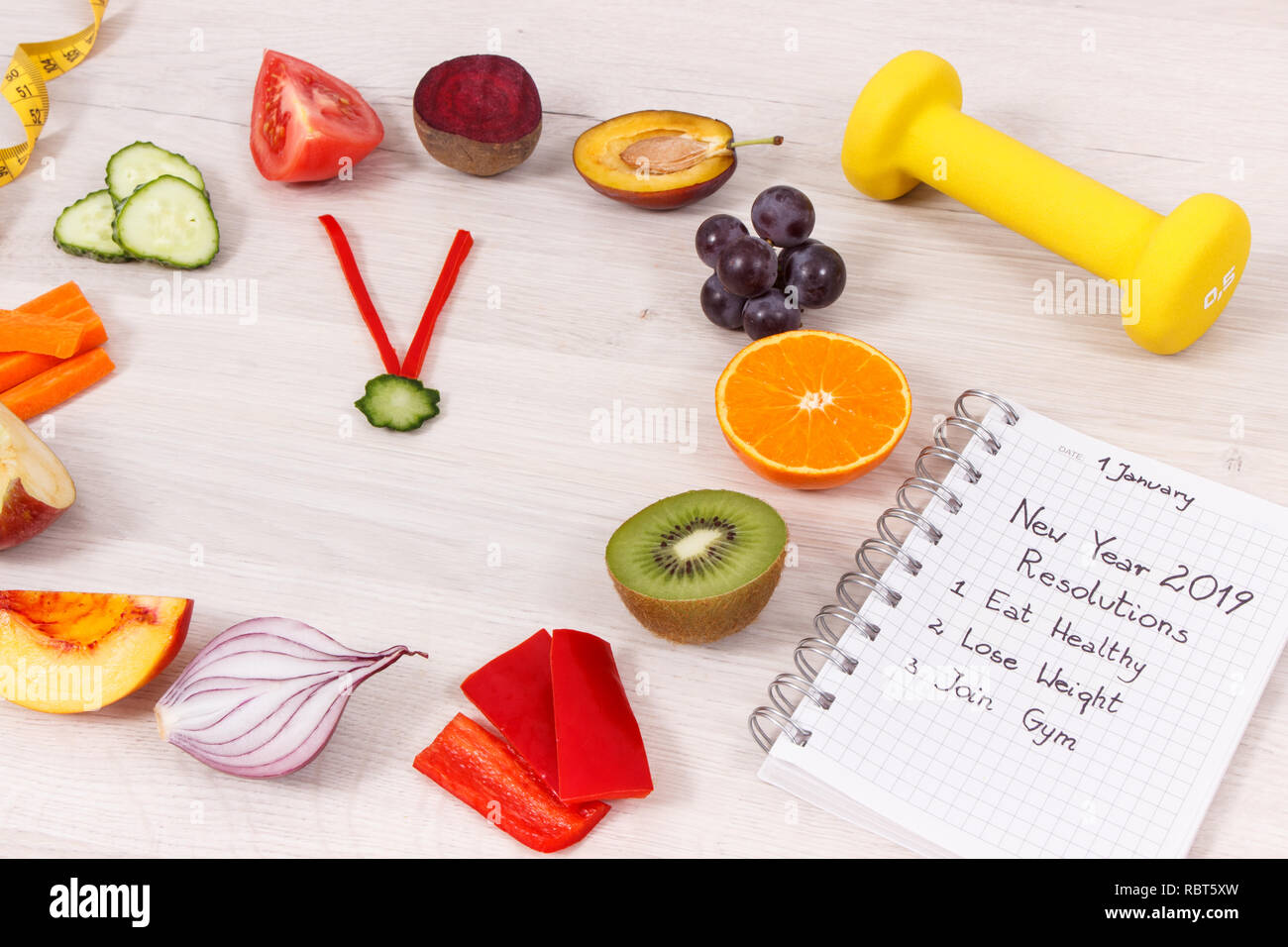 Fruits and vegetables in shape of clock, dumbbell for fitness and tape ...