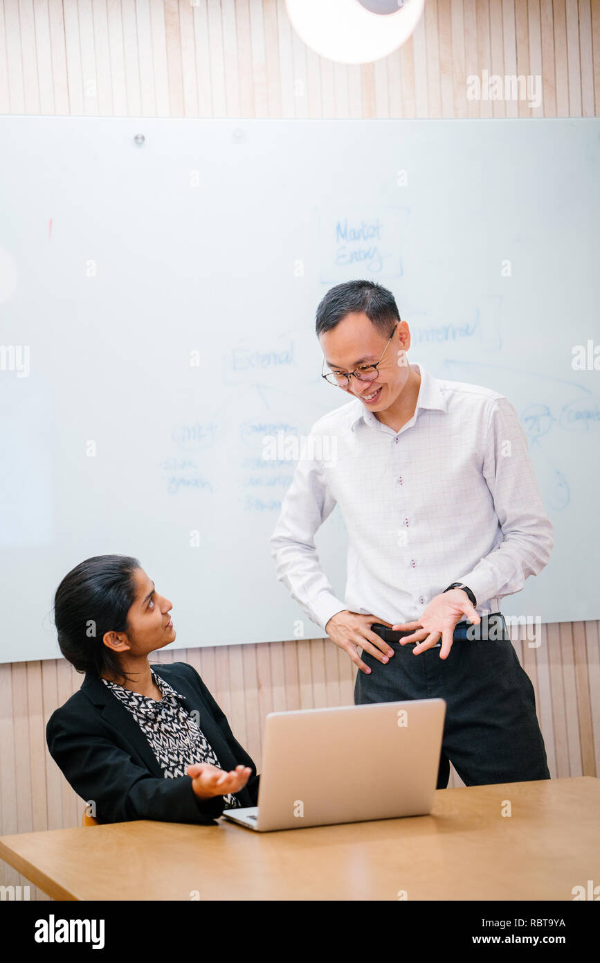 A diverse business team have a meeting discussion around a laptop in ...