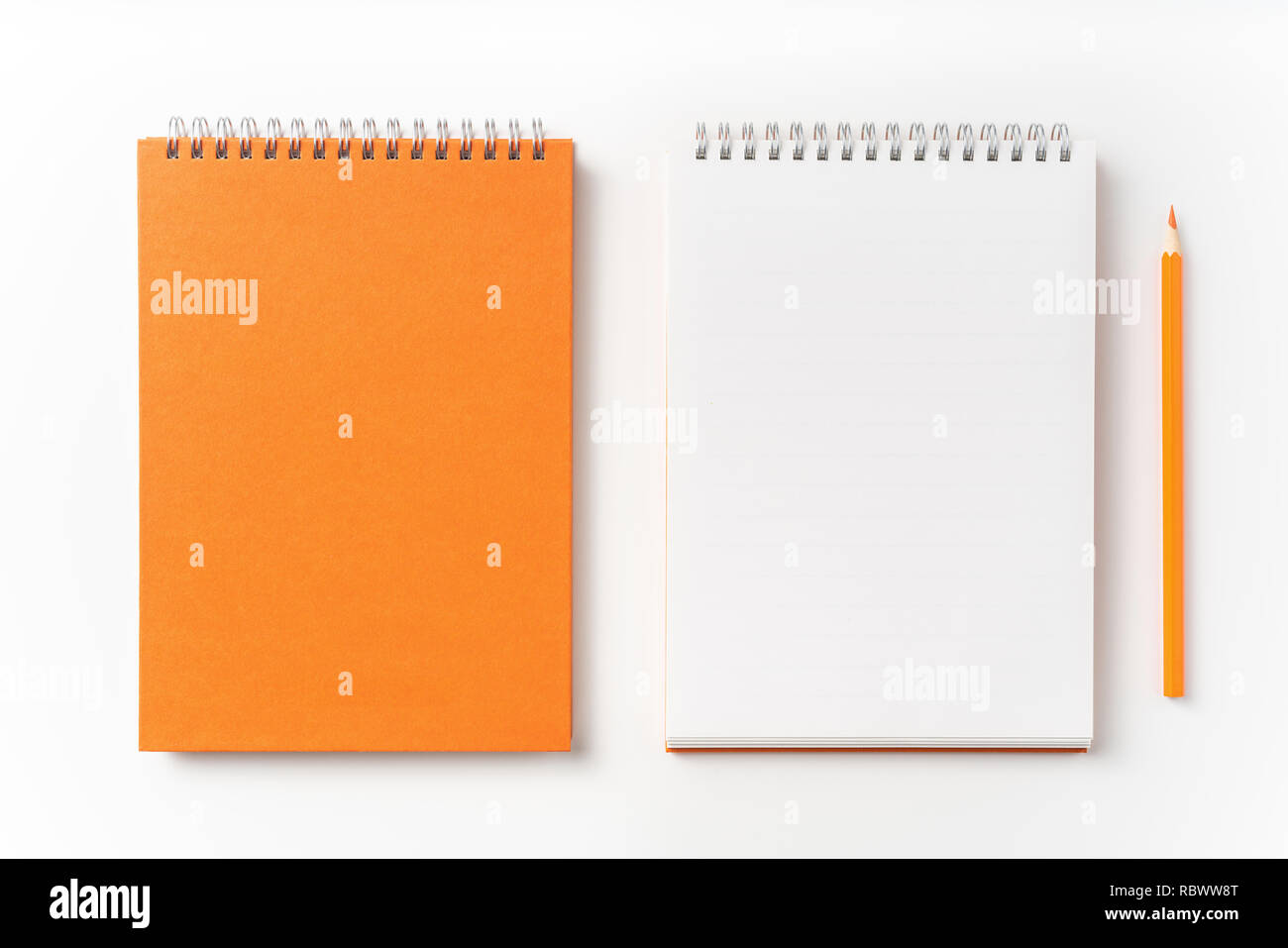 Design concept - Top view of orange spiral notebook, white page and ...