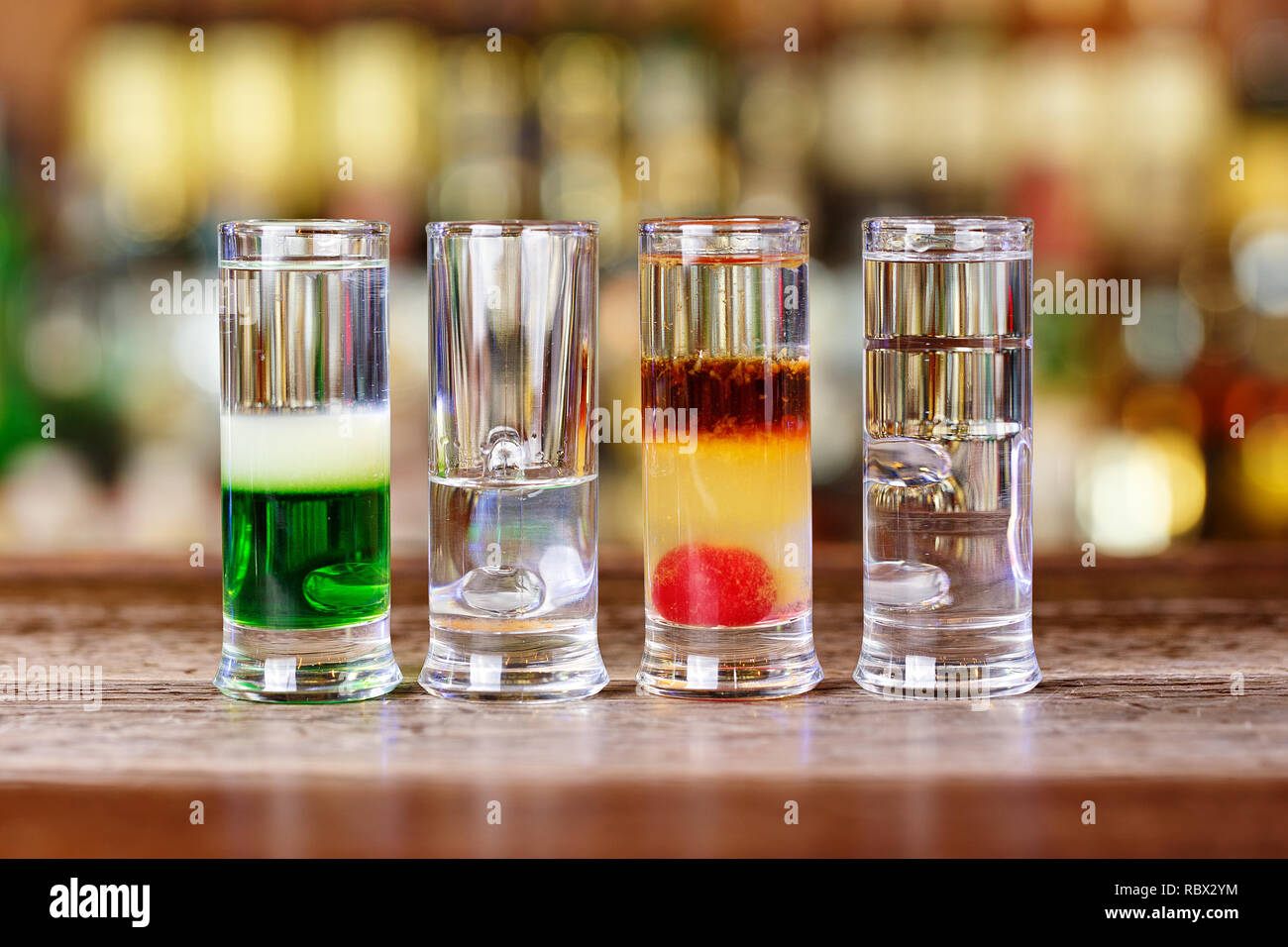 Cocktails of different alcohol in a nightclub stand in a row on the bar ...