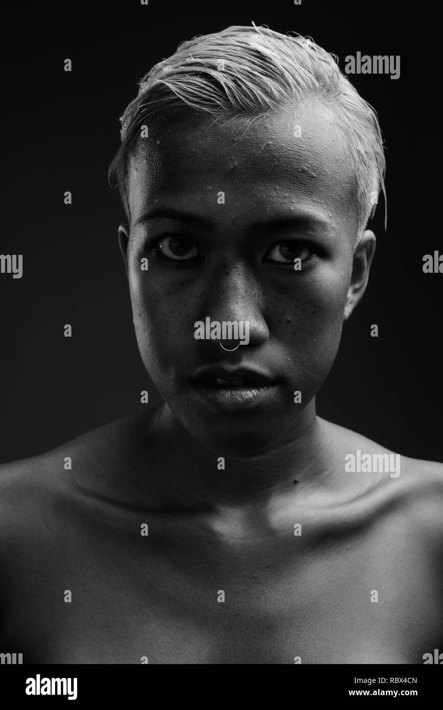Young beautiful rebellious woman with short hair against gray ba Stock ...