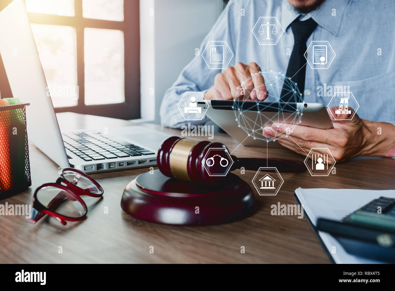 Male judge using touhpad and working with laptop computer and gavel on ...