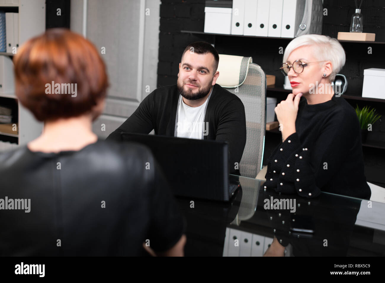 female candidate sits in front of two young men at interview Stock ...