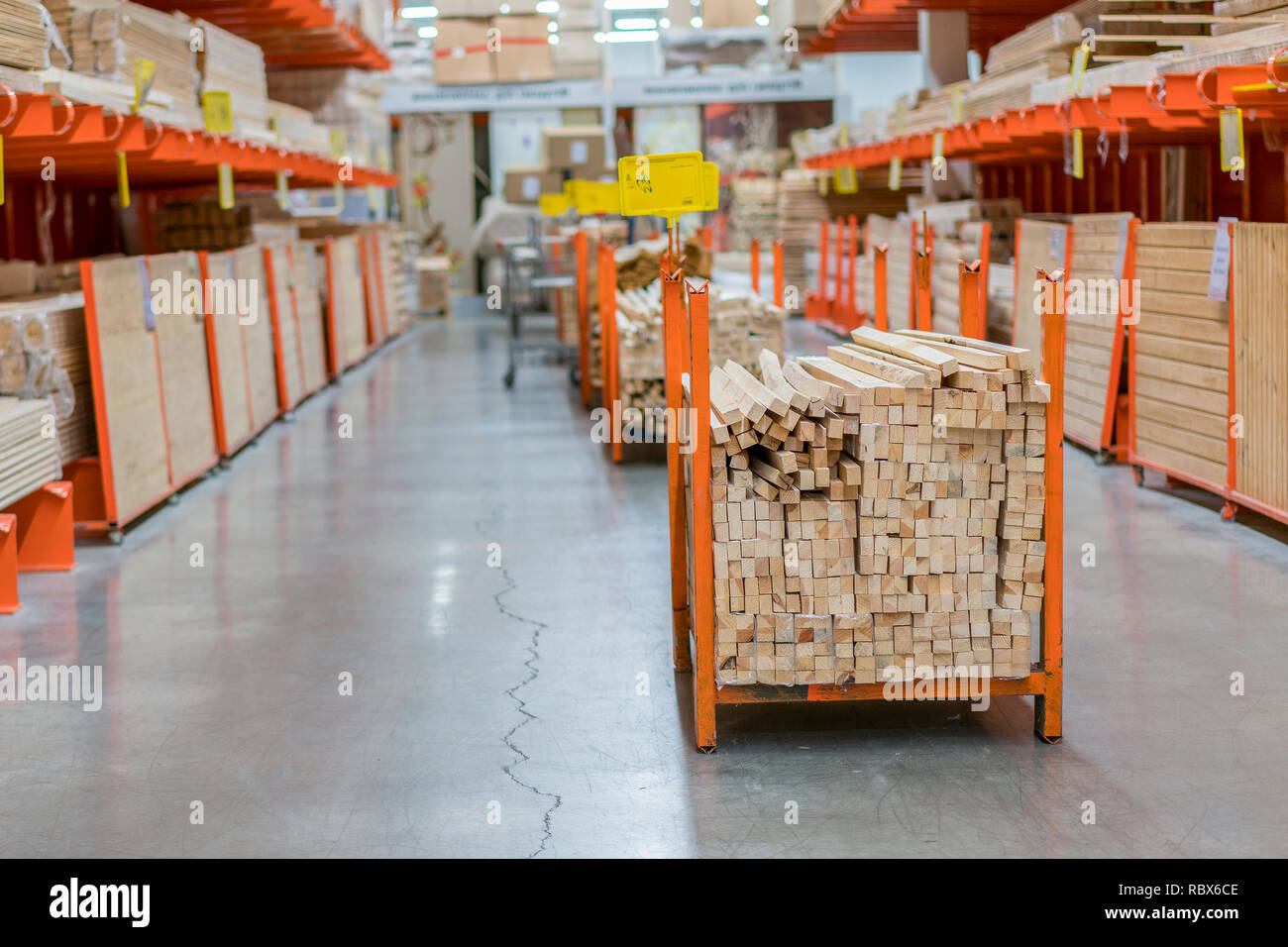 stack new wooden bars on shelves inside lumber yard of large hardware ...
