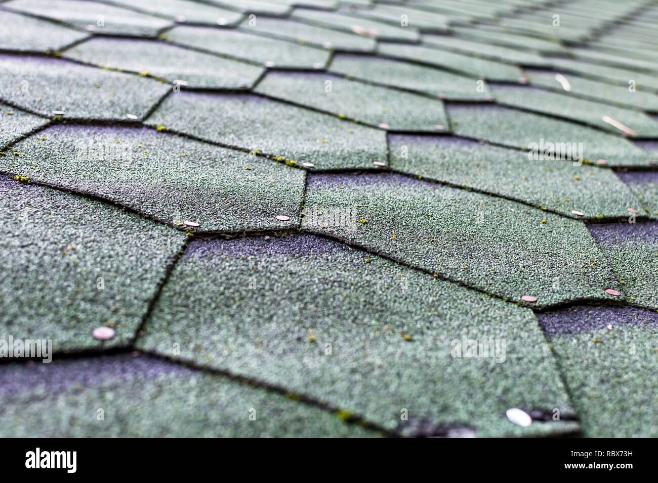 Fragment of green shingle tile texture roof for background. Closeup ...