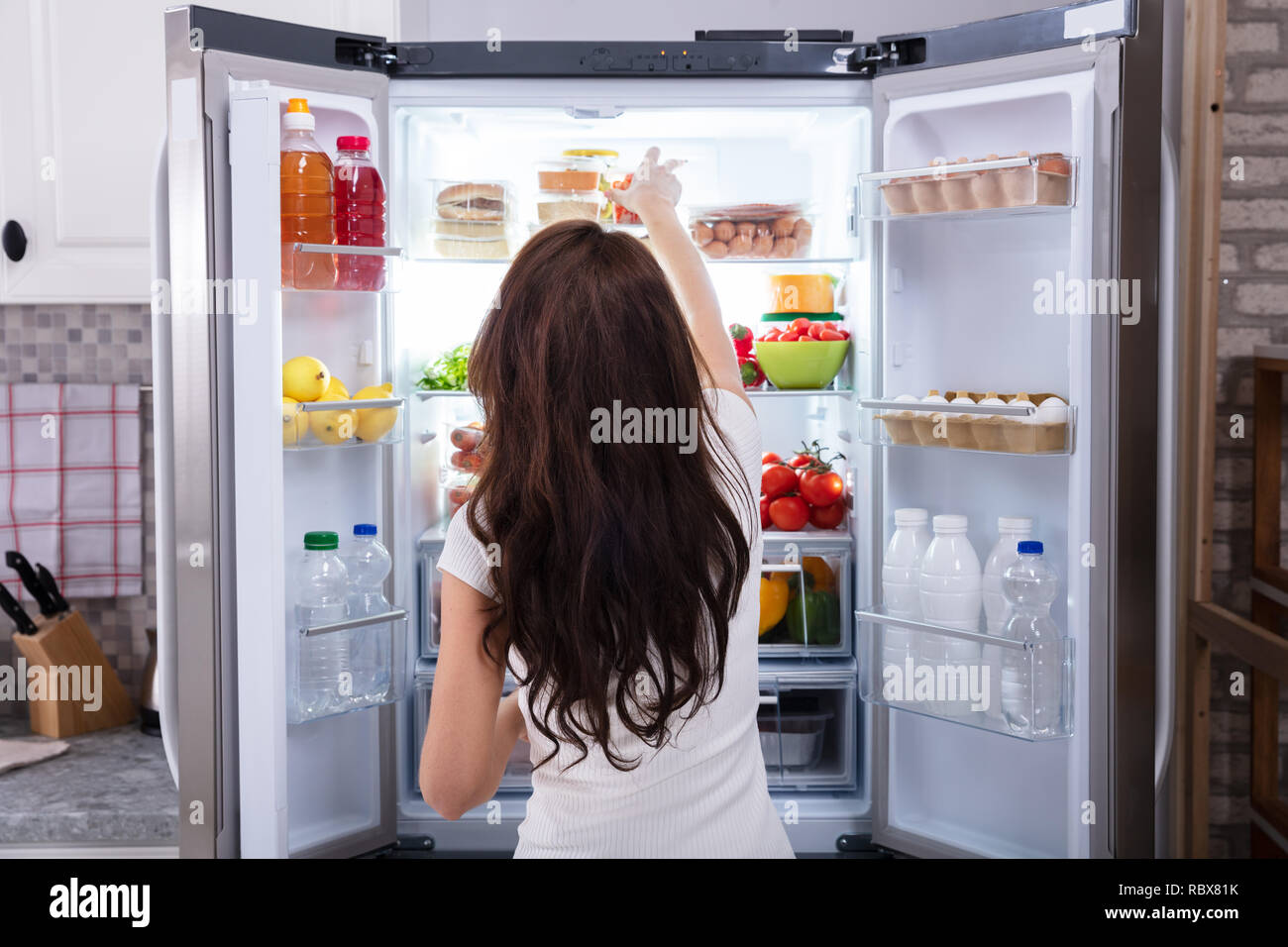 Rear View Of A Young Woman Taking Food To Eat From Refrigerator Stock ...