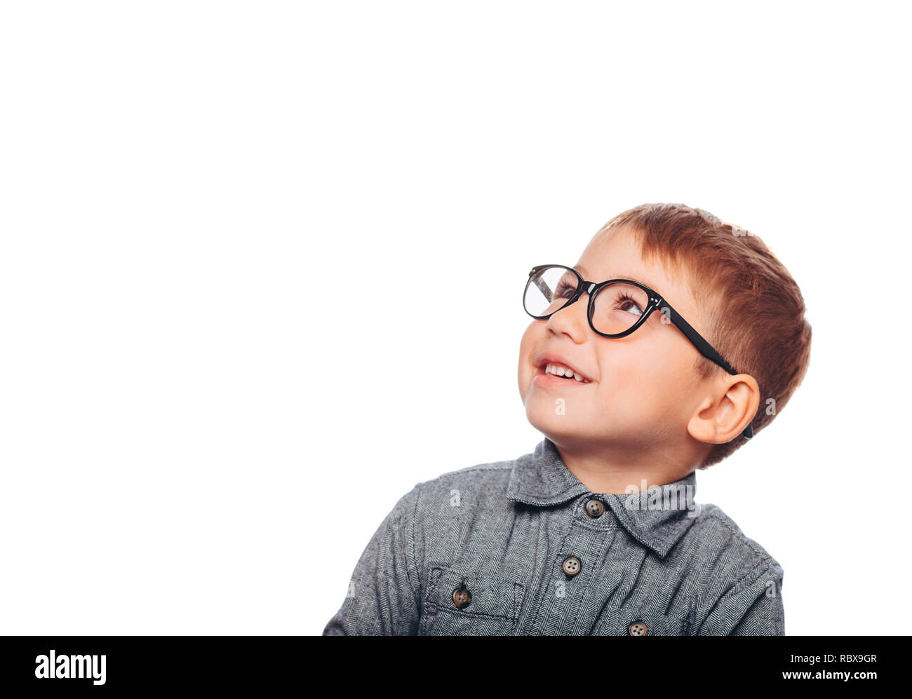 Portrait of little positive boy with eyeglasses smiling at camera ...