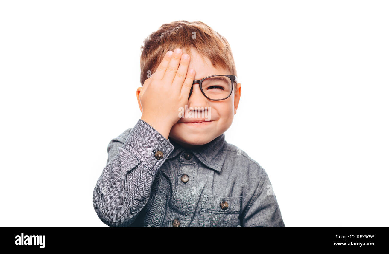 Portrait of little positive boy with eyeglasses smiling at camera ...