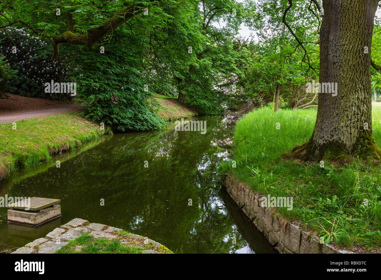 Water ditch channel on grassy meadow in summer city park Stock Photo ...