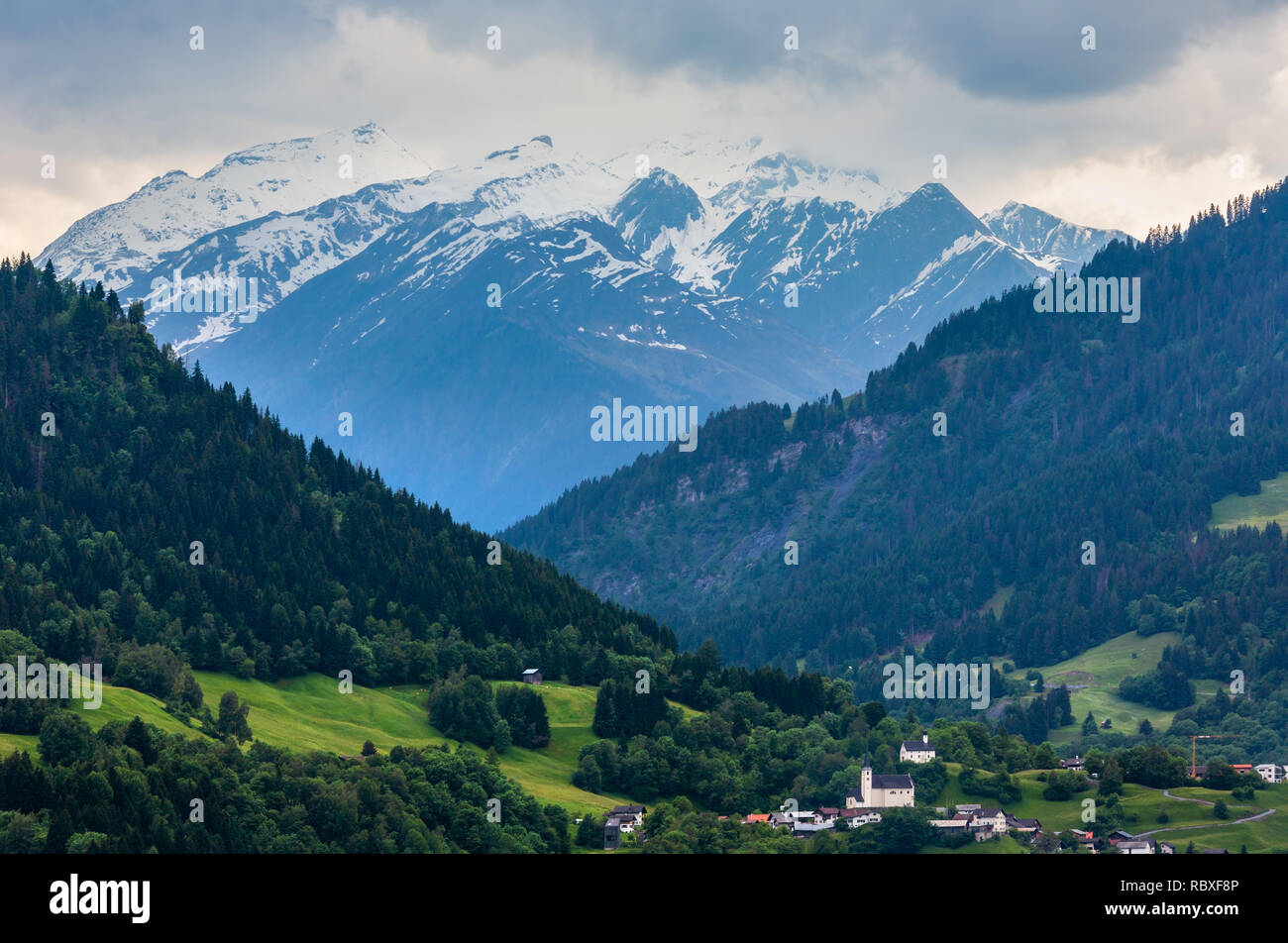 Summer Alps mountain landscape with village, fir forest on slope and ...