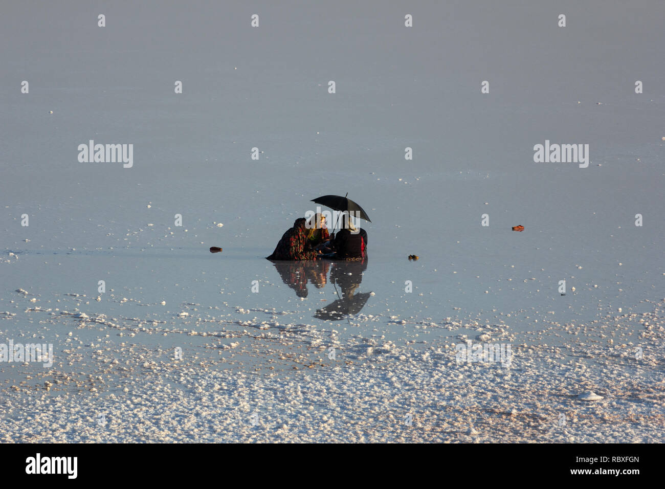 A family sitting on salt flat of Urmia Lake, West Azerbaijan province ...