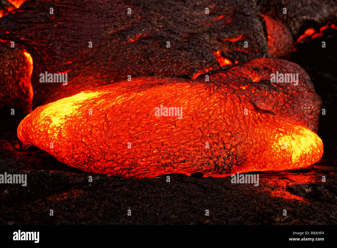 Scenic view of a part of a lava flow in the dark, the hot lava shows up ...