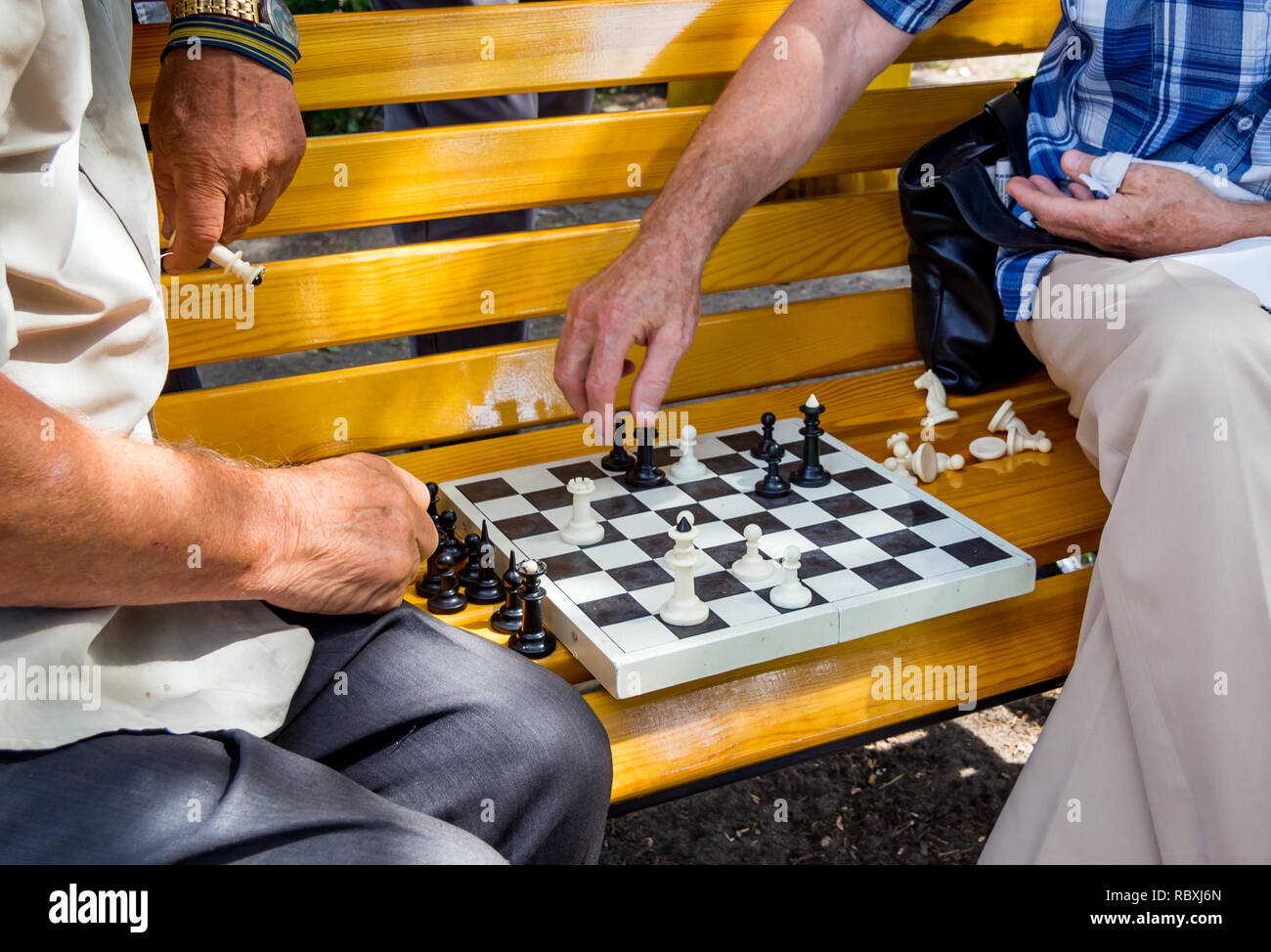 Chess game closeup on a city park bench Stock Photo - Alamy