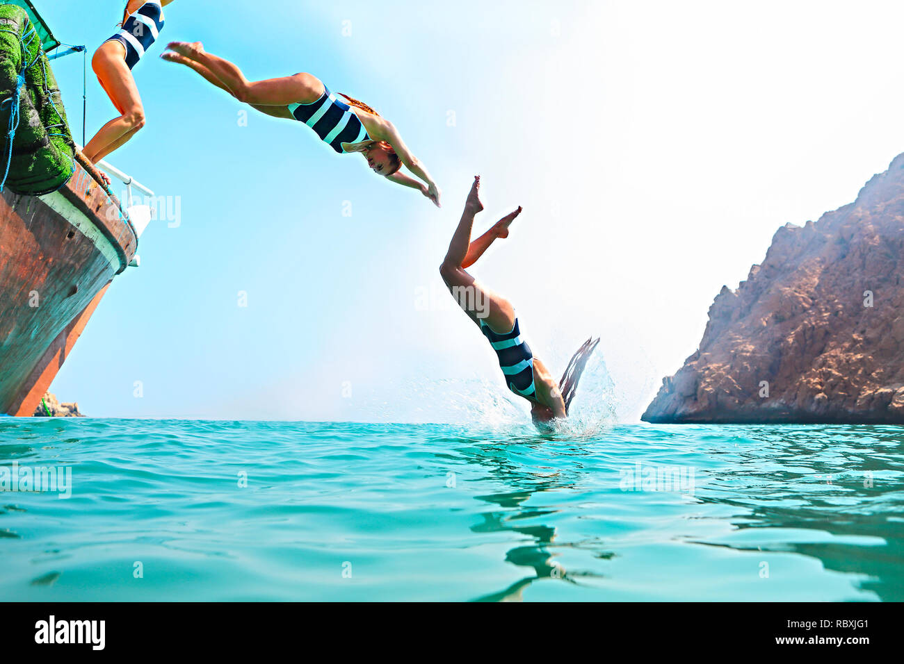 Young woman jumping from a sailing boat. One model. Summertime, travel ...