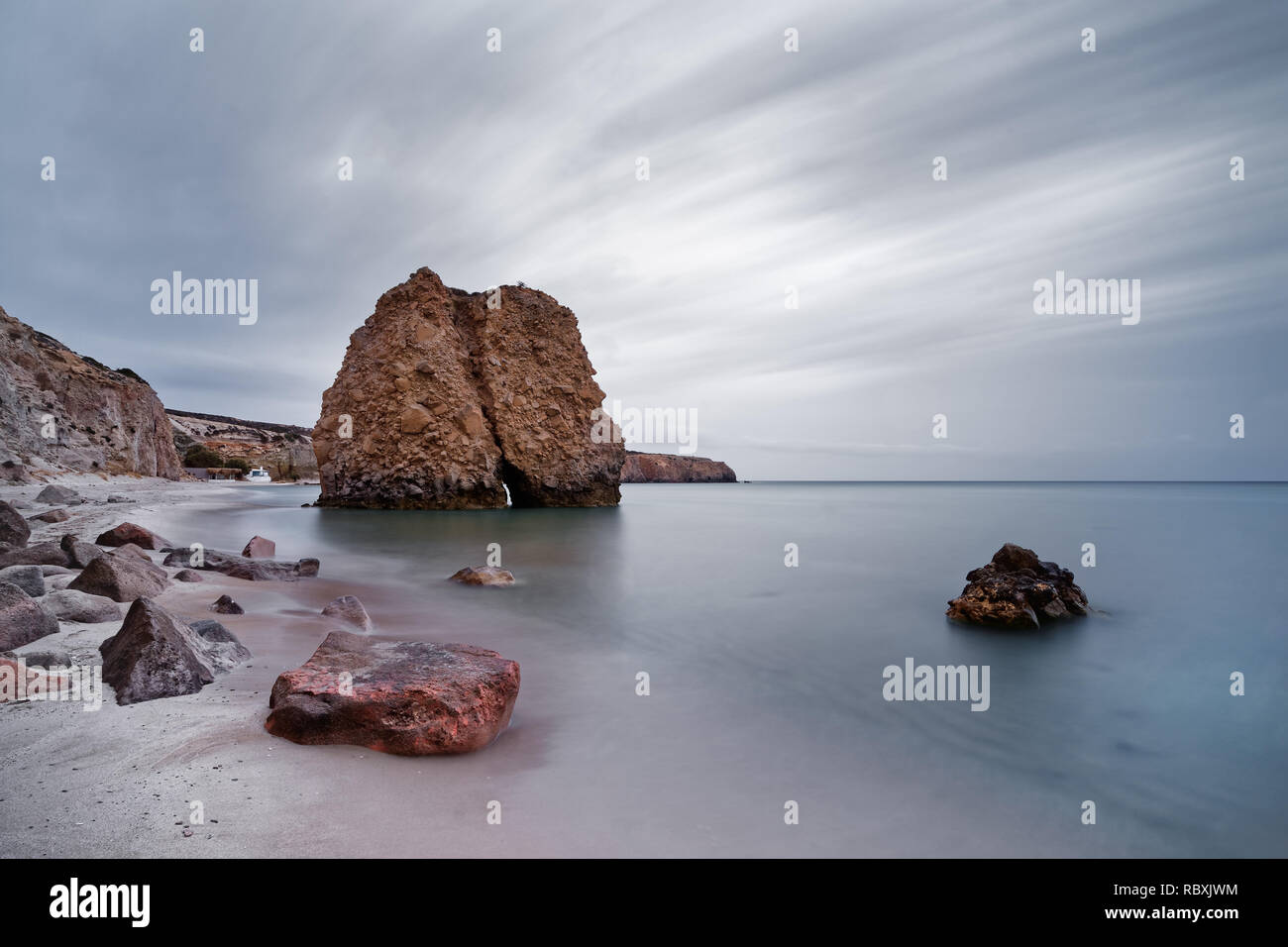 Lonely long beach with differently sized stone blocks in reddish hues ...