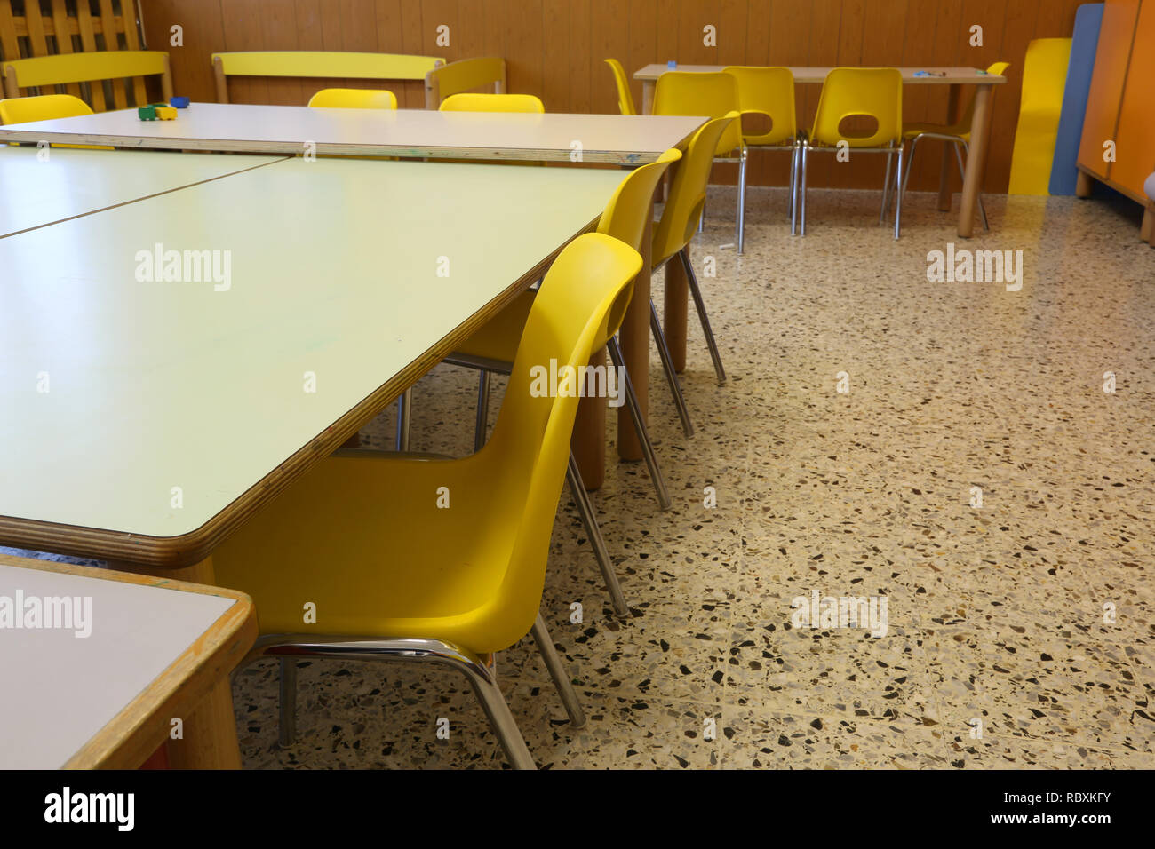 inside a school classroom of a school with small yellow chairs and ...
