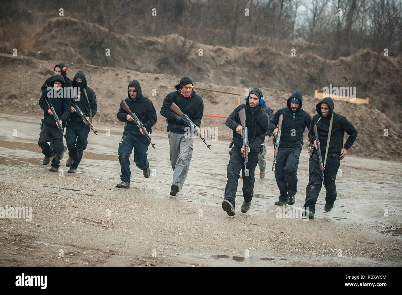 Large team, group of civilian people have action training with rifle ...