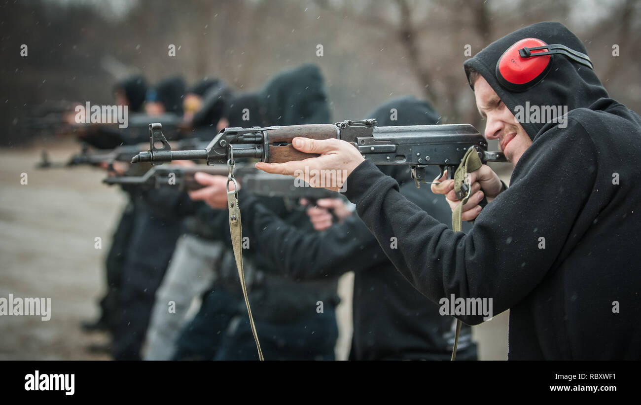 Large team, group of civilian people have action training with rifle ...