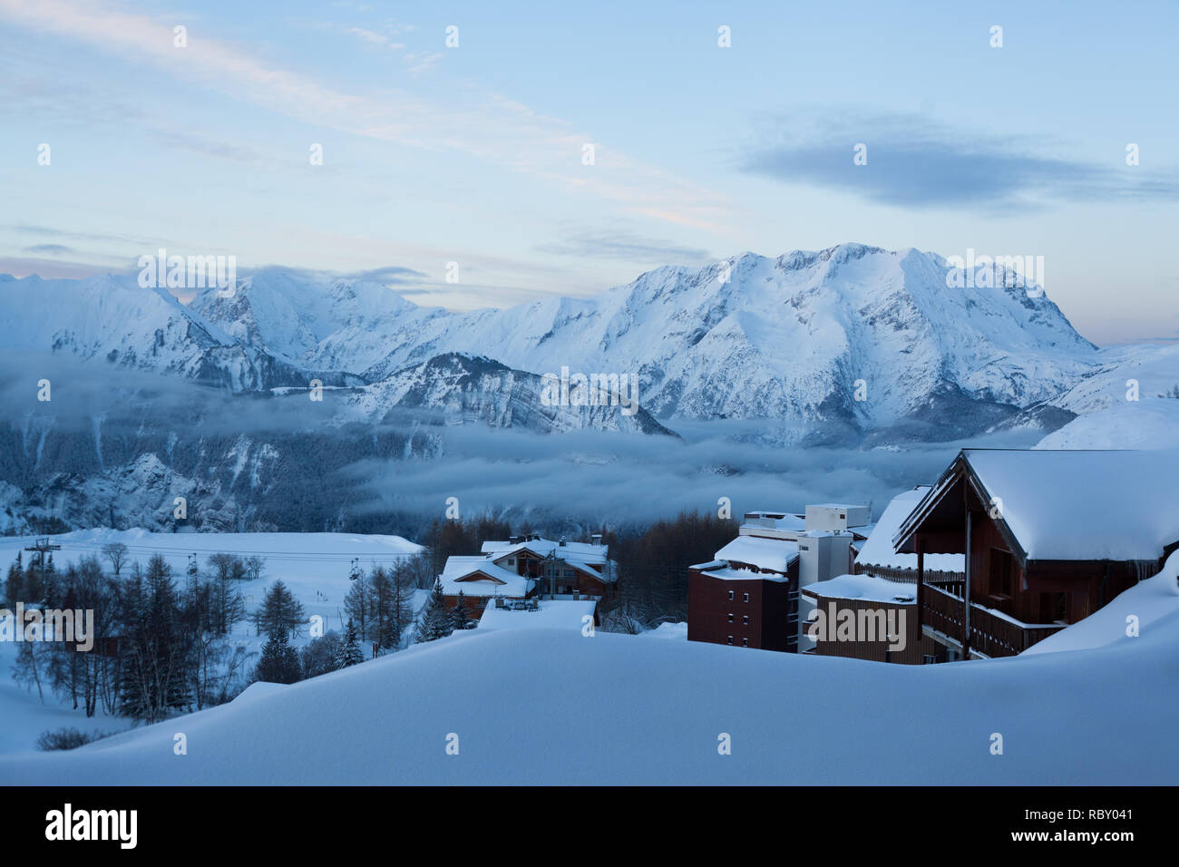 Dusk view of Alp d' Huez ski resort in French Alps with wooden chalets ...