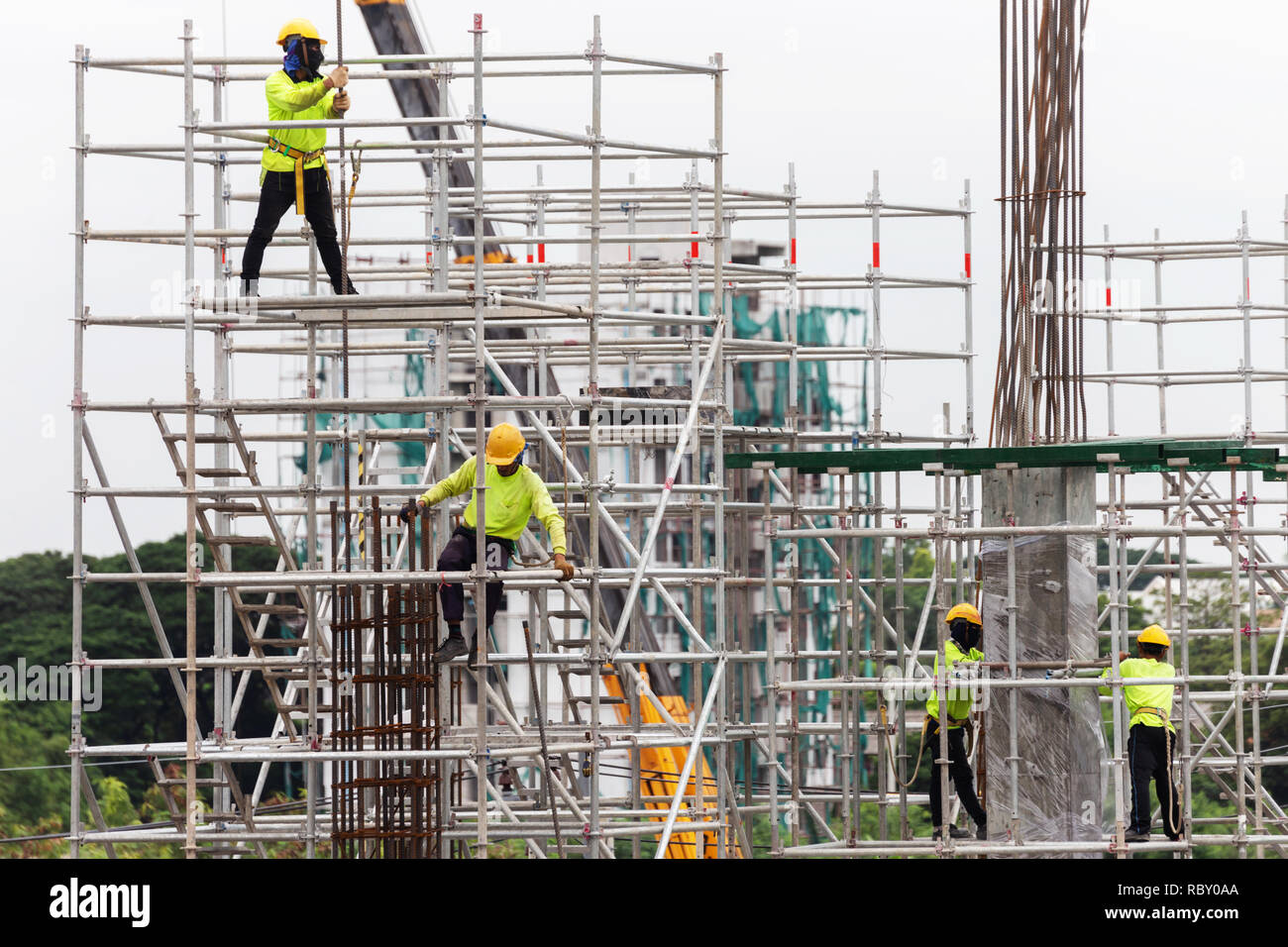 asian construction workers working on scaffolding of building ...