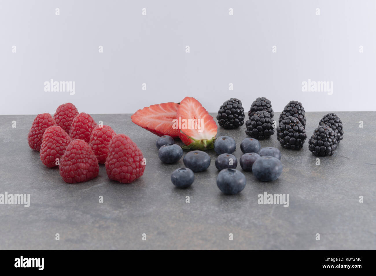 Fresh berries on a plate of granite on a white background. - Imagen ...