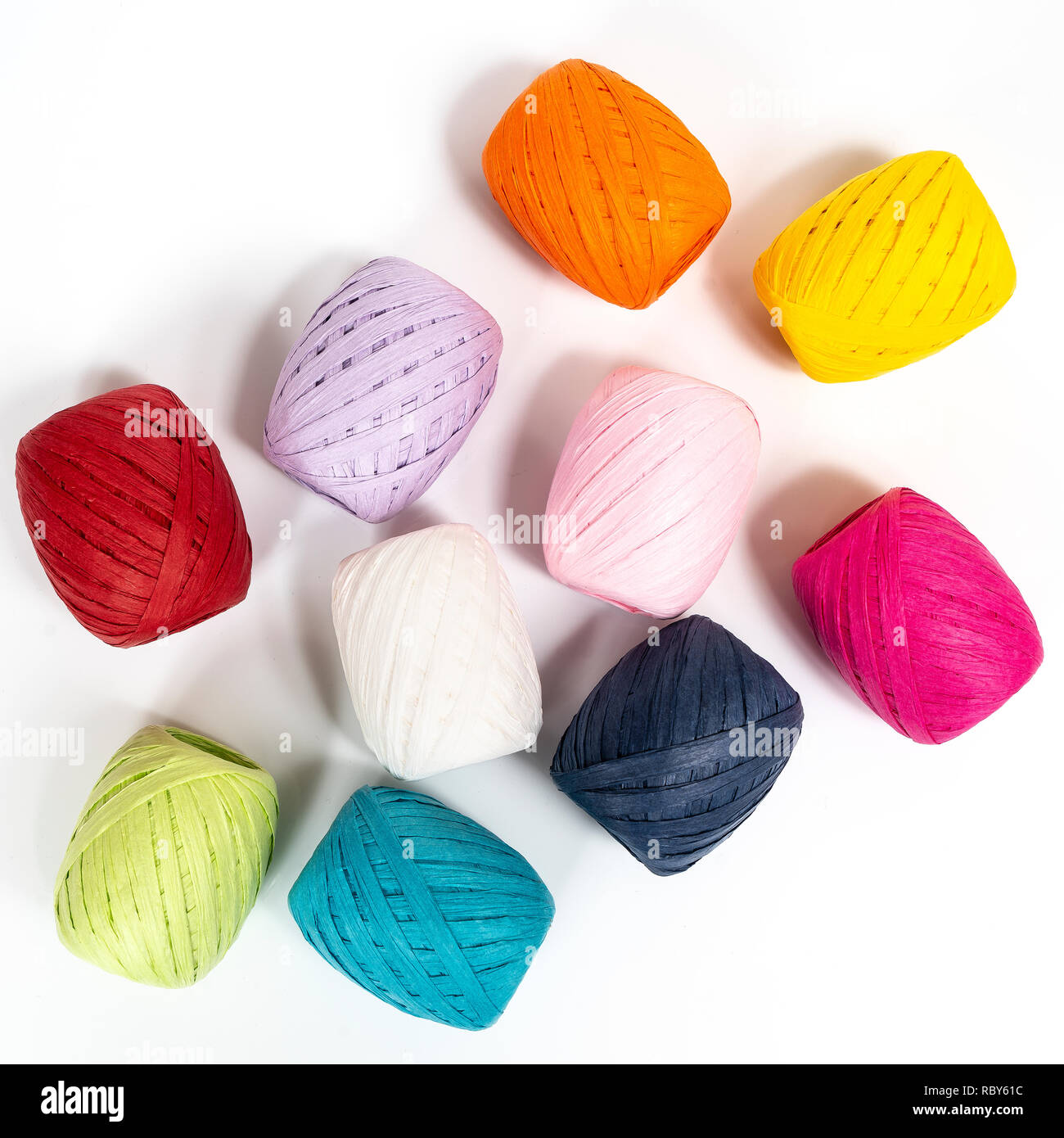 some balls of colored raffia on a white surface Stock Photo - Alamy