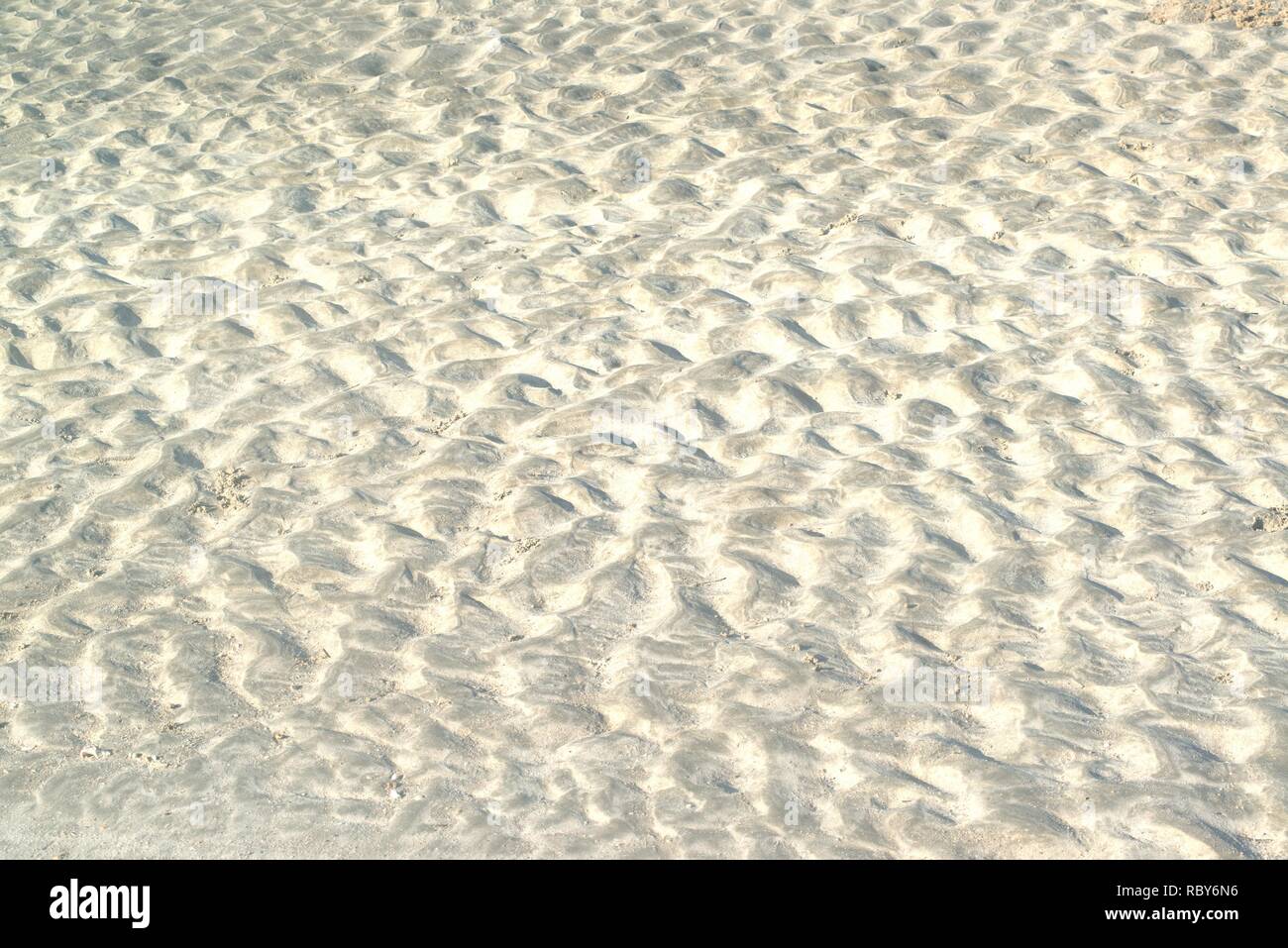 Sand rippled textured pattern and background created by low tide on a ...