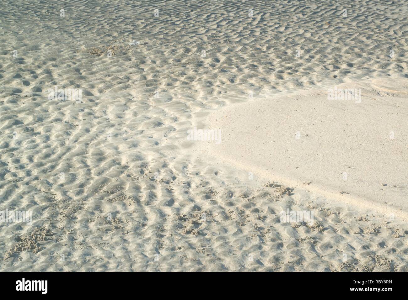 Sand rippled textured pattern and background created by low tide on a ...