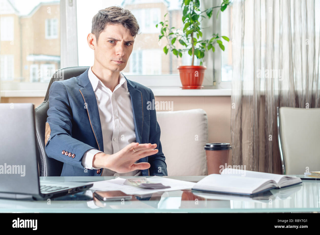 The official businessman sitting at workplace in office refuses bribes ...
