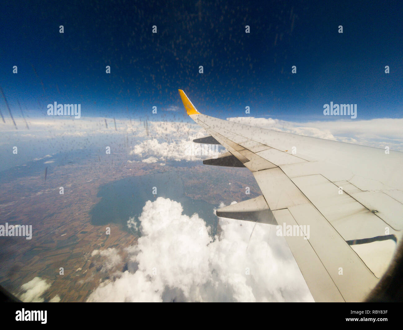 Clouds view from a commercial airplane and a wing of an airplane window Stock Photo - Alamy