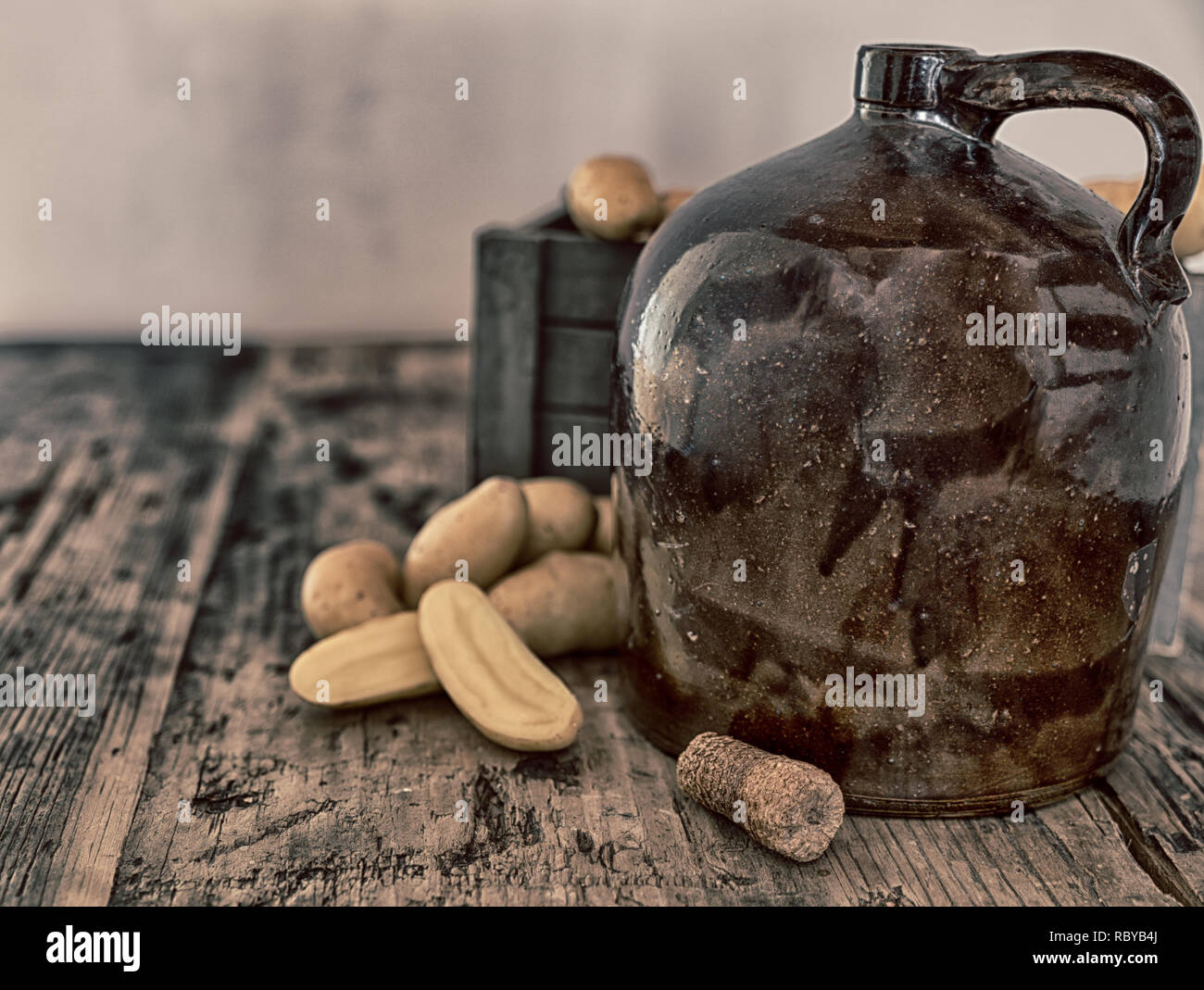 vintage moonshine jug on a rustic wooden table with potatoes and corn ...