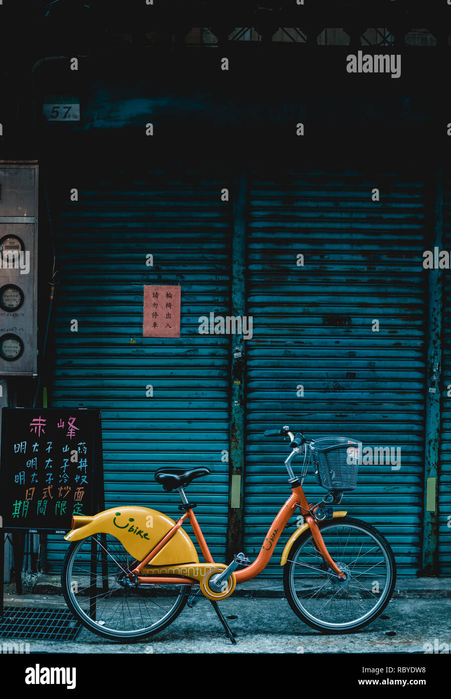 Youbike - public bicycle sharing service. Yellow bicycle with blue wall ...
