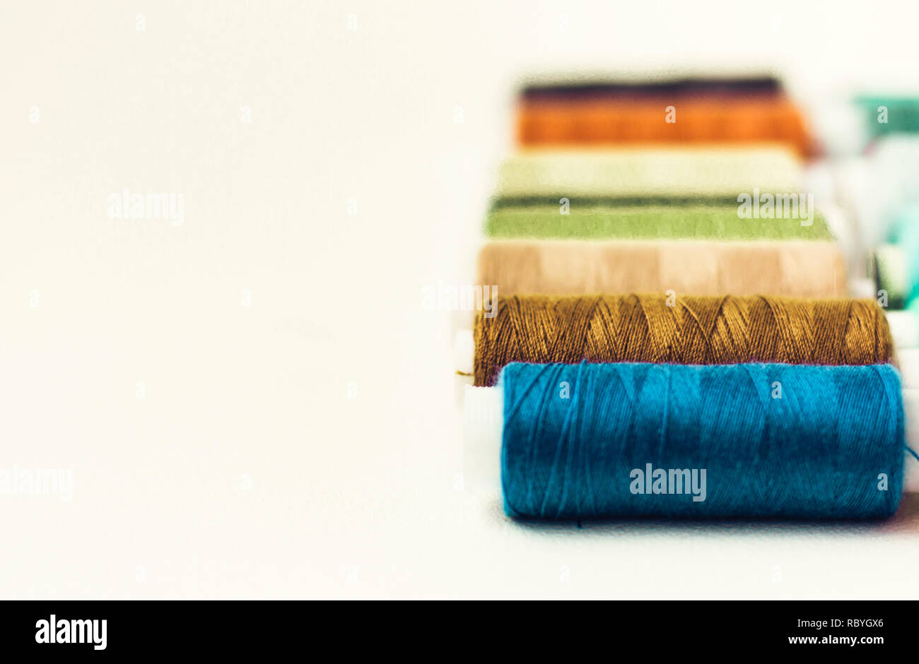 Colored sewing thread coils on white background with copy space for ...