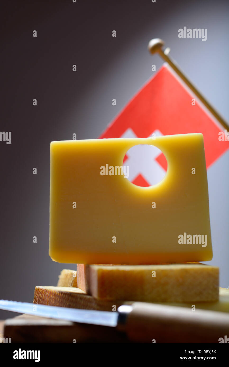 Block of Swiss Emmental or Emmentaler medium-hard cheese with round ...