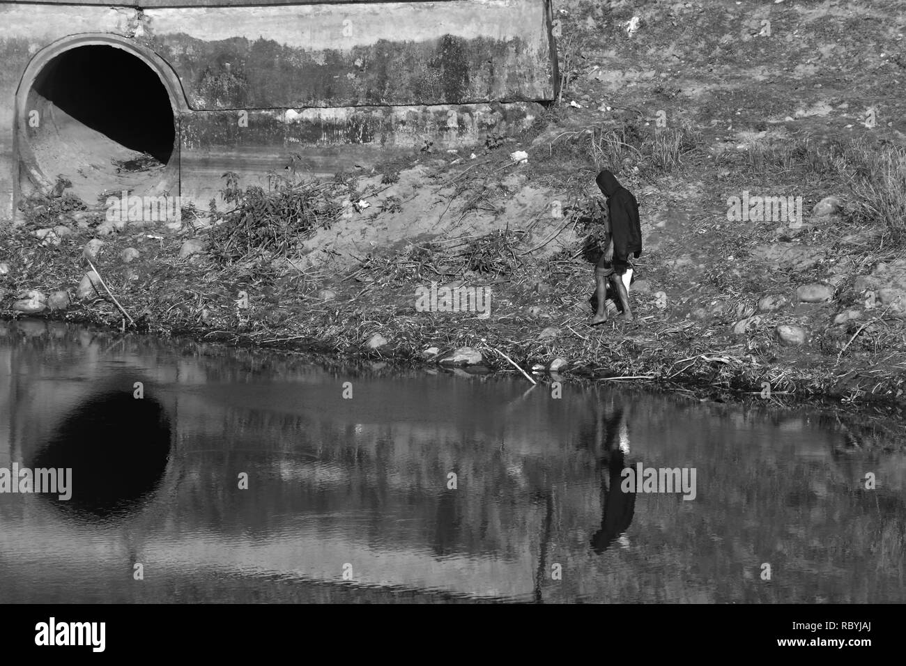 A random man walking behind a round culvert, Black & White Stock Photo ...