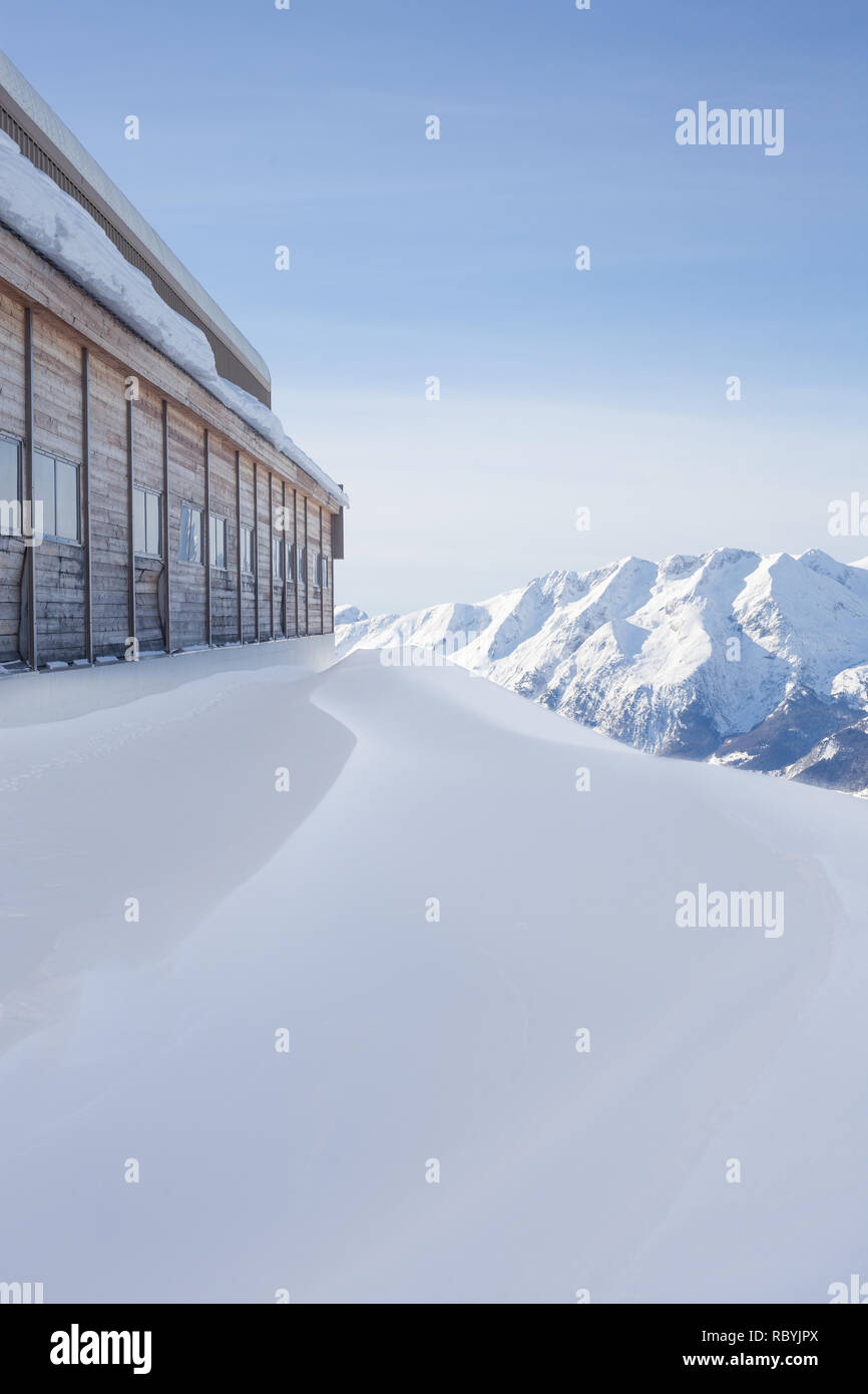 Snowdrift alongside wooden building in the ski resort of Alp d'Huez in ...