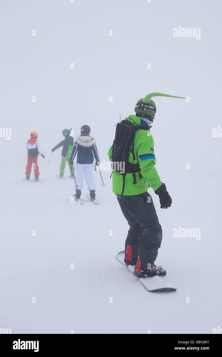 Family ski together downhill, view from behind Stock Photo - Alamy