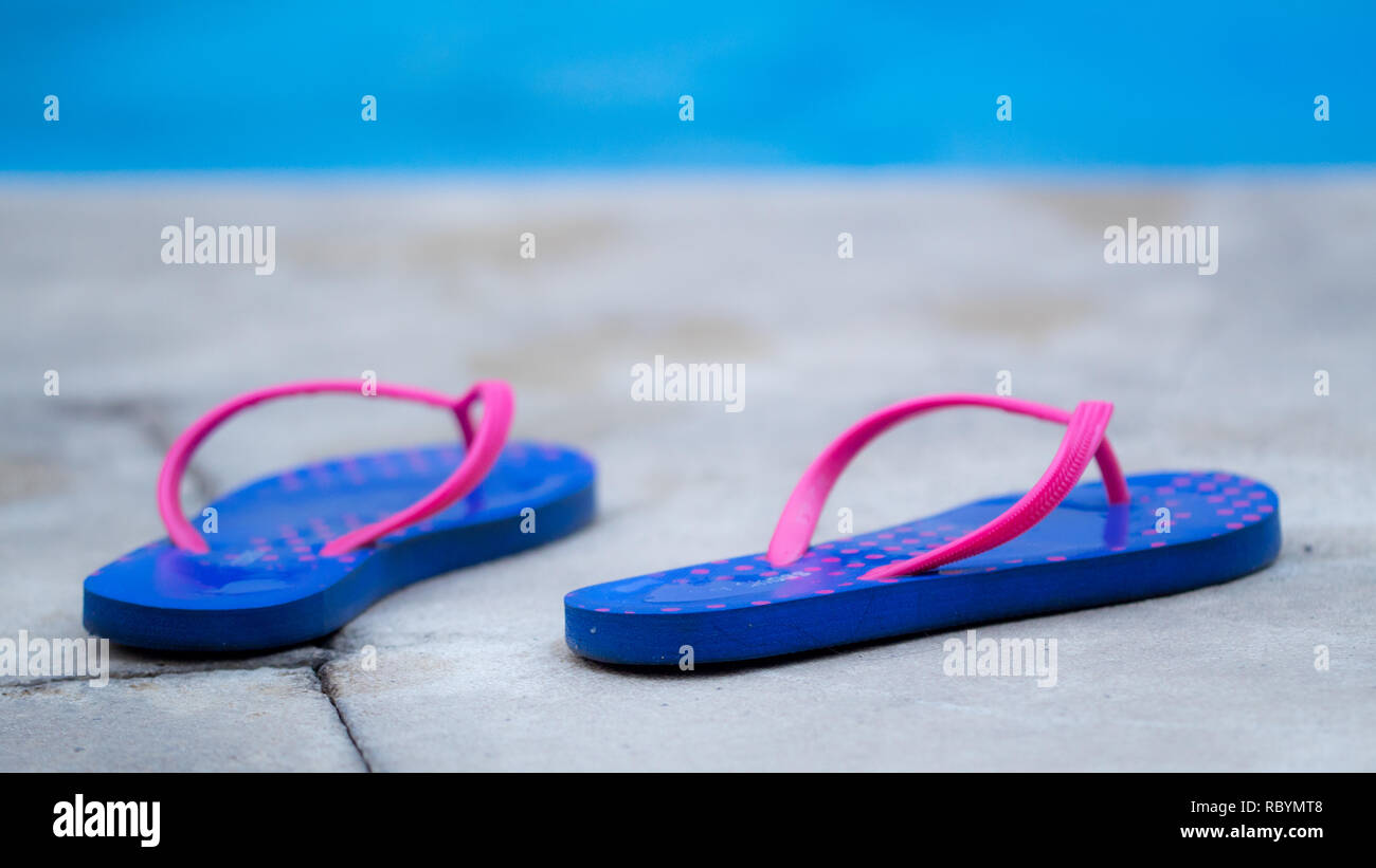 A photo of a pair of flip-flops at a pool Stock Photo - Alamy
